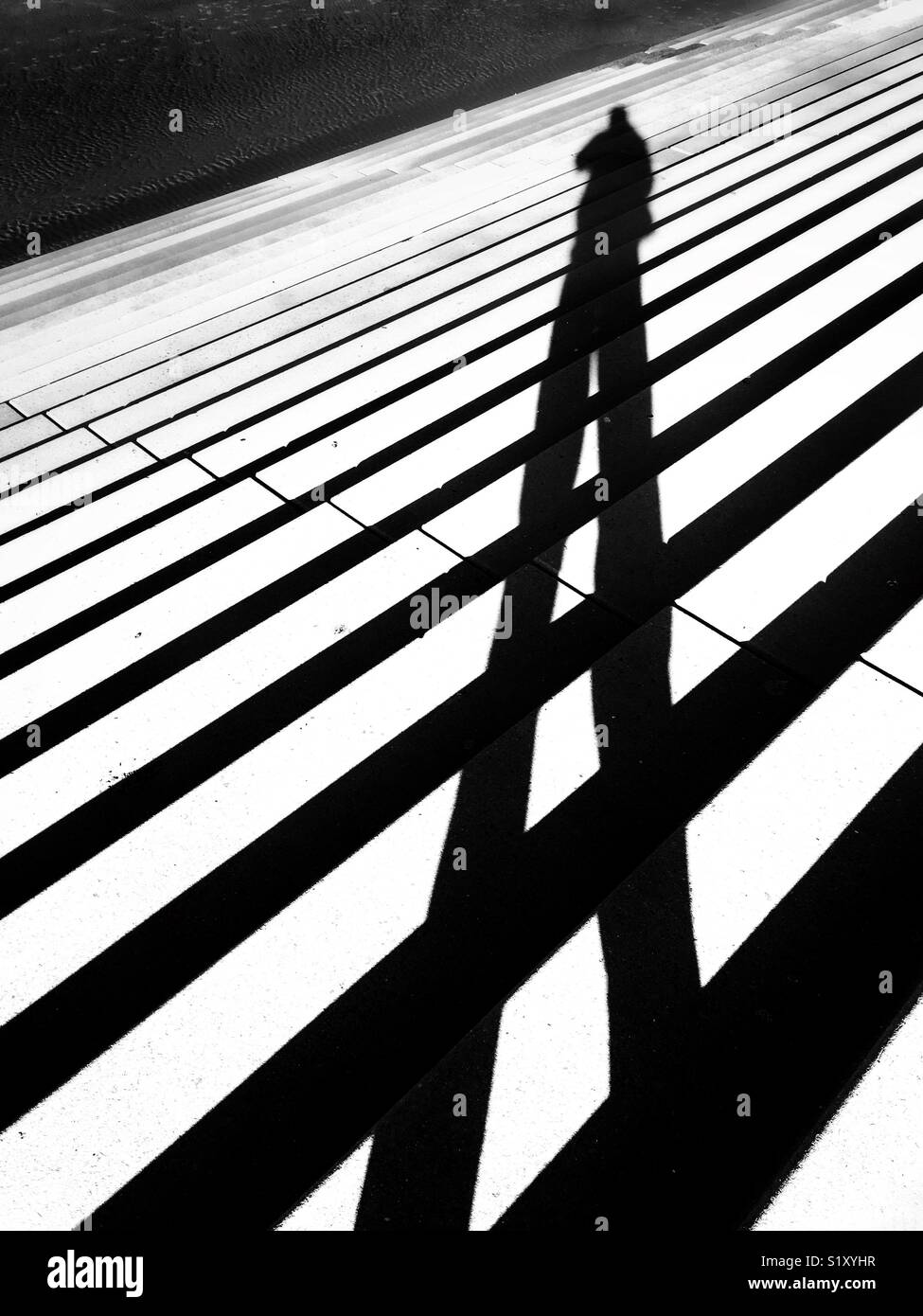 Shadow of figure on steps creating a graphic pattern Stock Photo - Alamy
