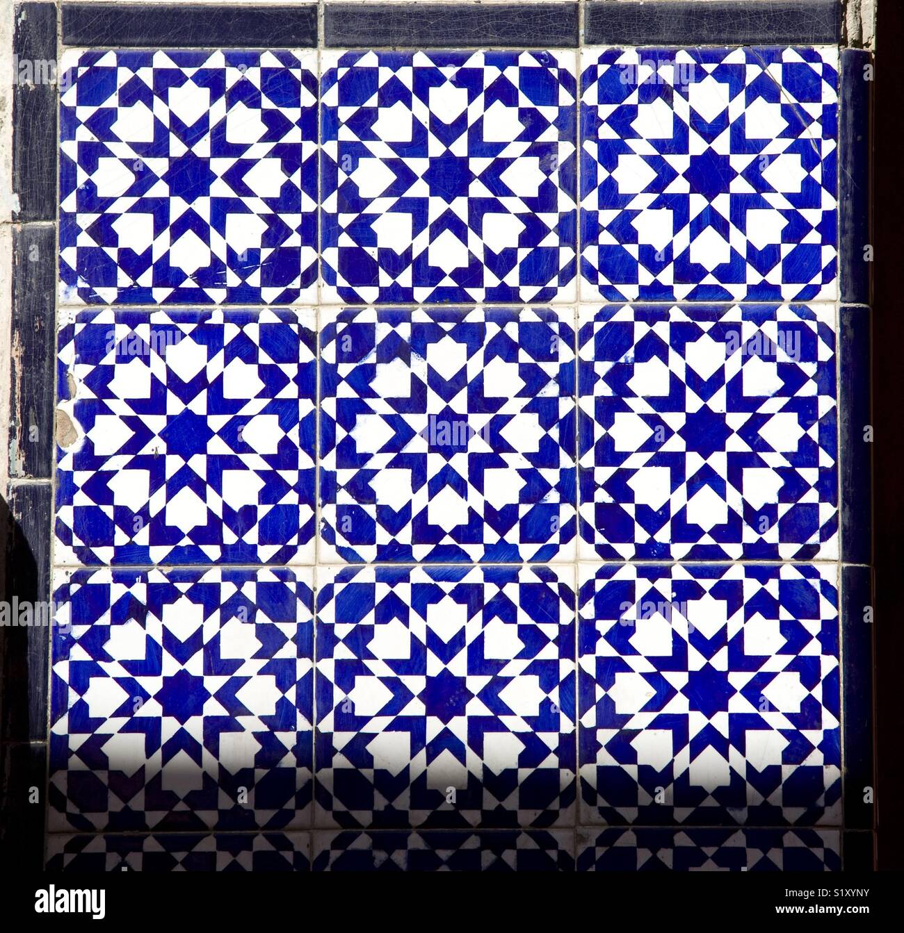Traditional blue Moroccan tile shines in the sunlight on a street in ...