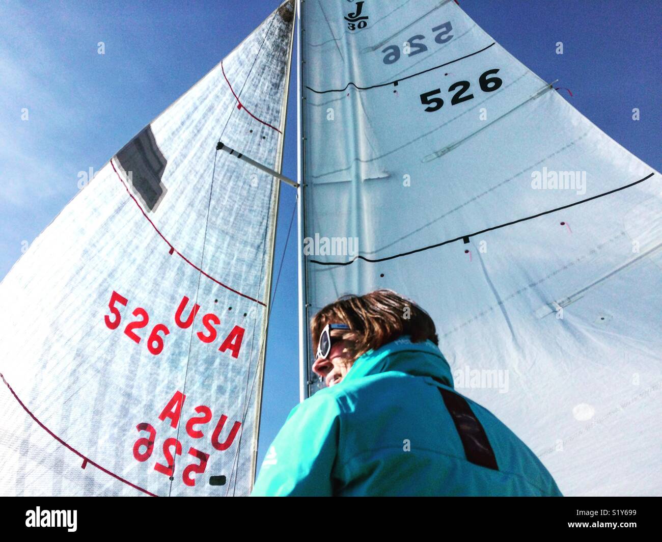 A female sailor trimming sails during a winter race in Annapolis Stock ...