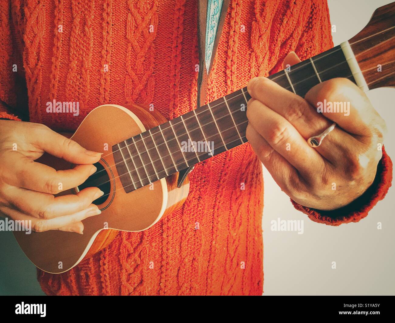 Woman playing soprano ukulele, indoors Stock Photo - Alamy