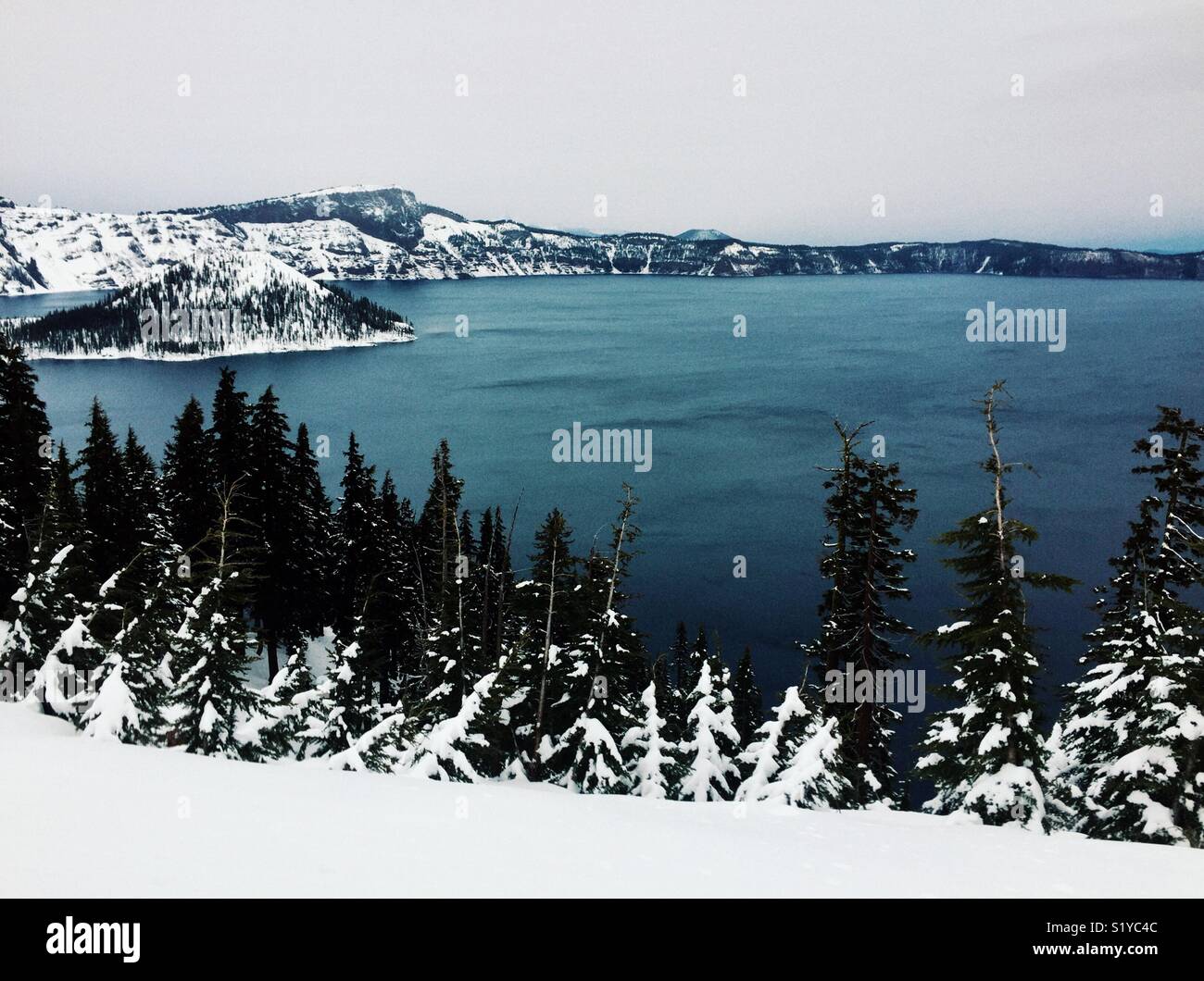 Winter scene, mountains, blue lake and trees at Crater Lake, Oregon ...