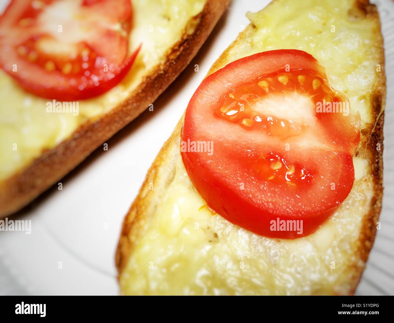 Sliced tomato on toasted cheese roll Stock Photo - Alamy