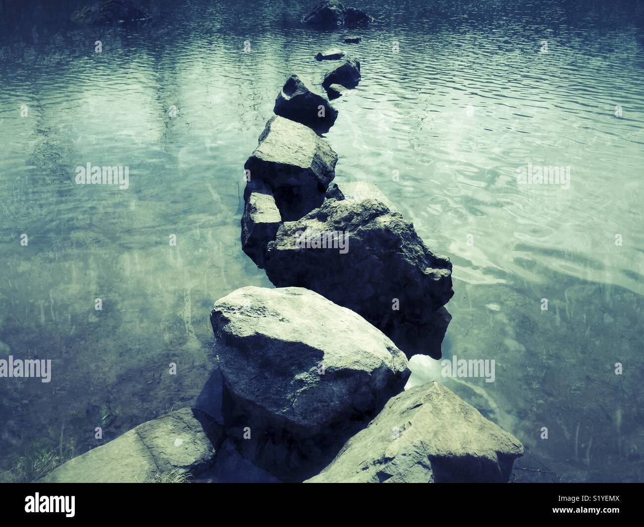 Rocks going into the water Stock Photo - Alamy