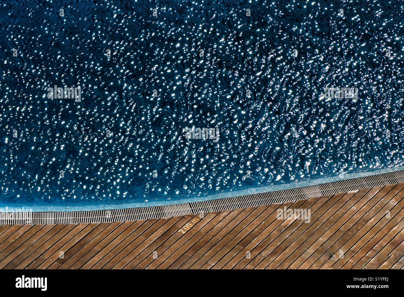 Sun reflection in a swimming pool with a wood deck Stock Photo - Alamy