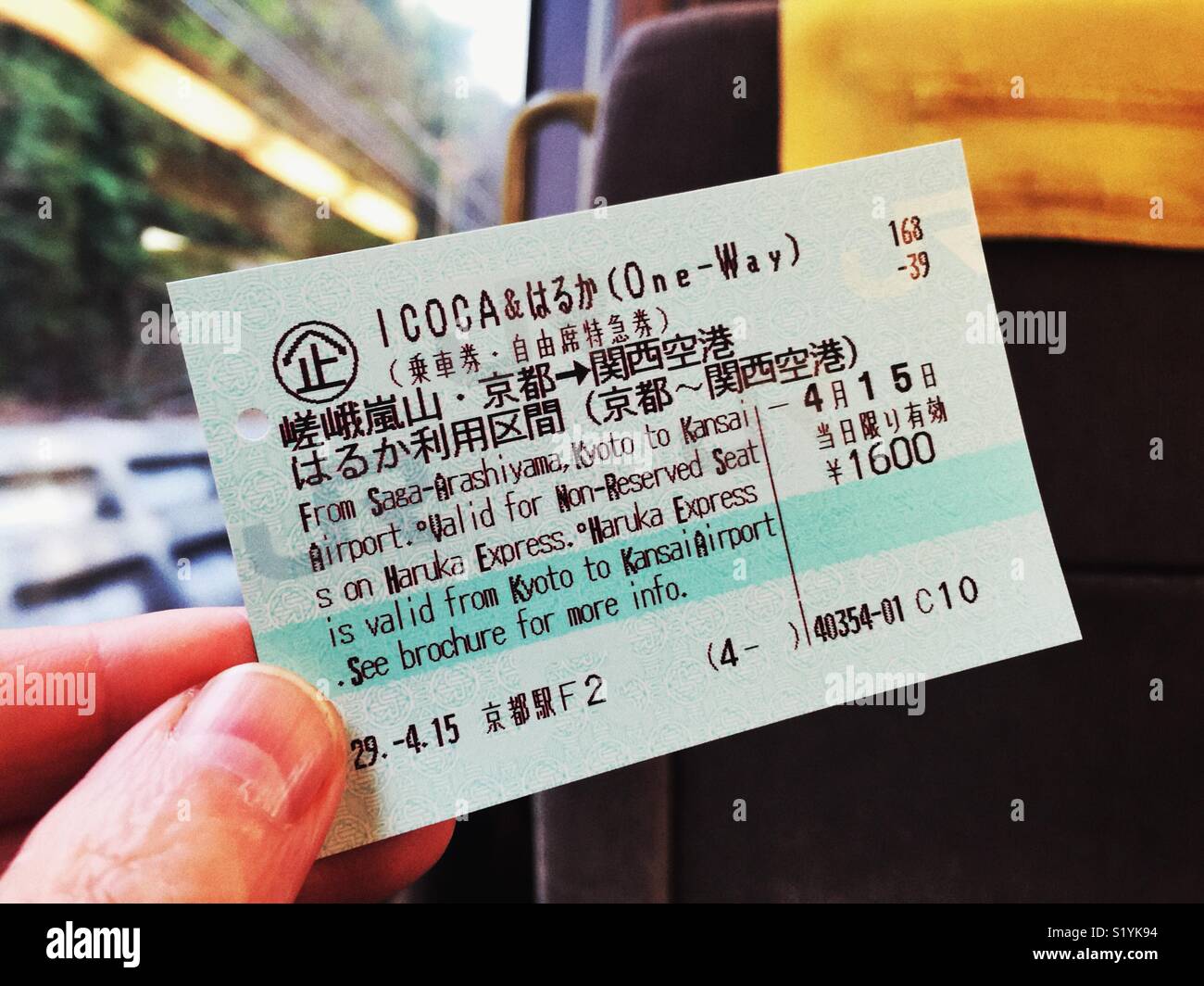 fingers holding train ticket from Kyoto to Kansai airport on the train ...