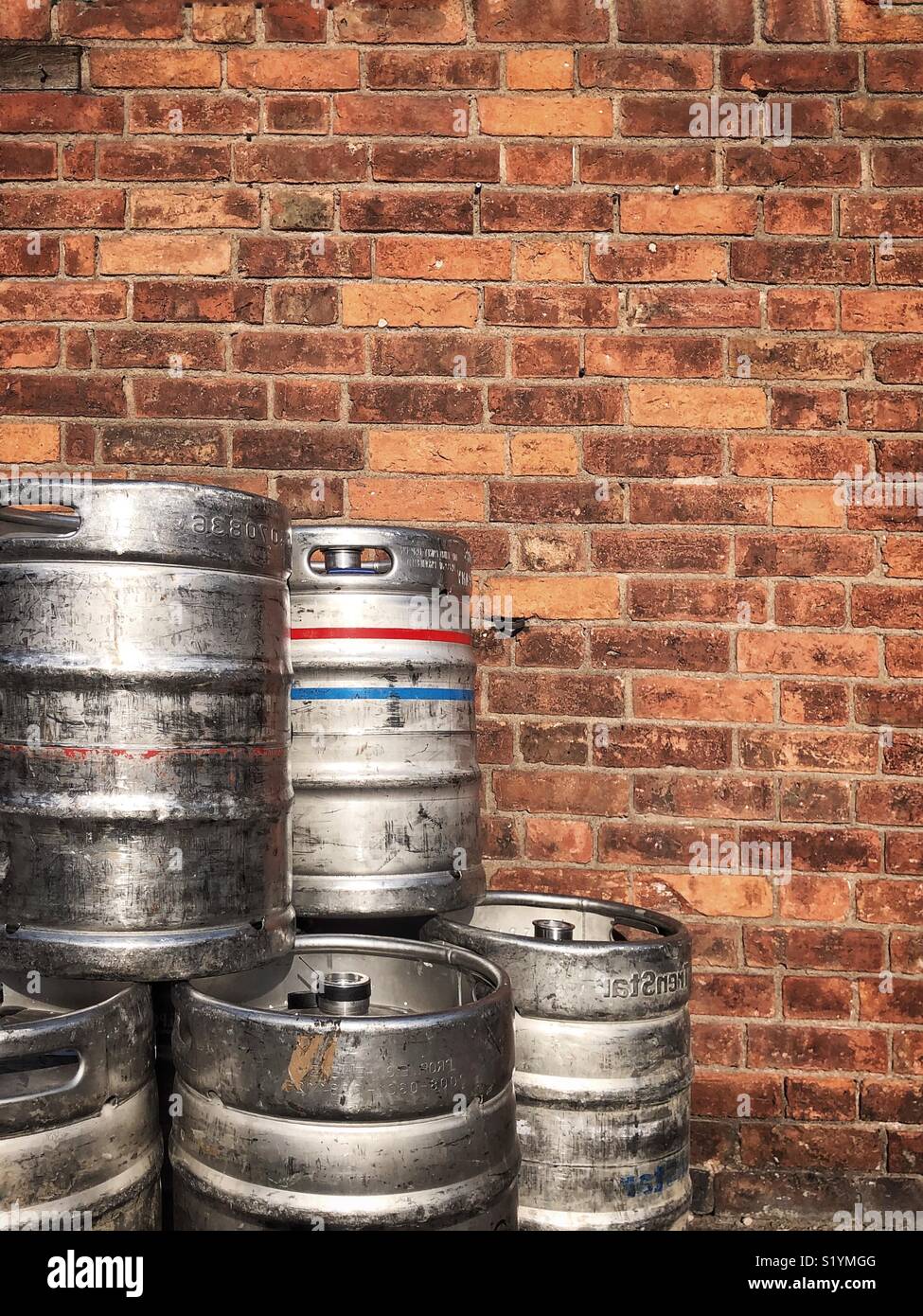 Beer barrels stacked up against a brick wall Stock Photo - Alamy