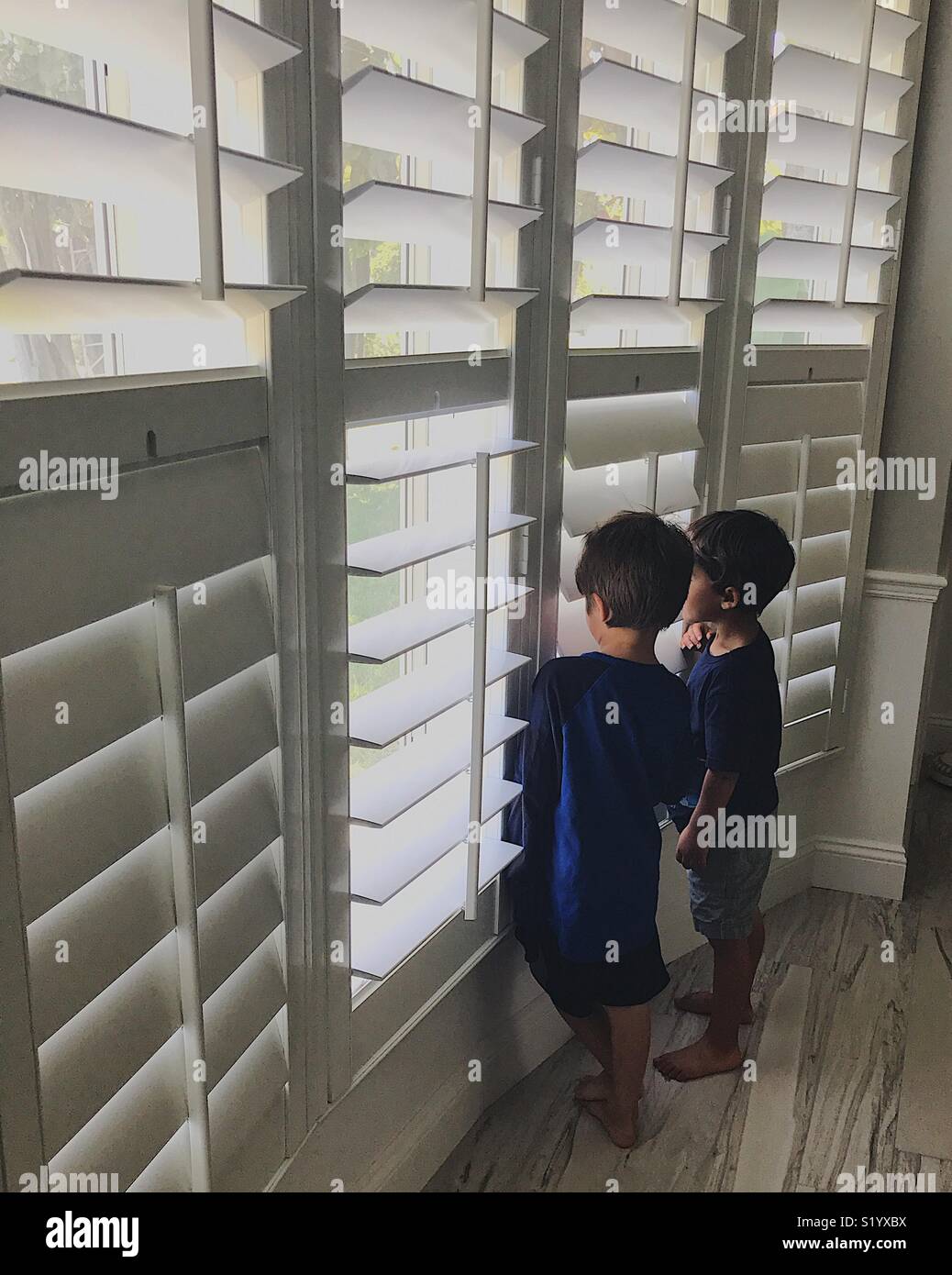 Boys watching out of window Stock Photo - Alamy