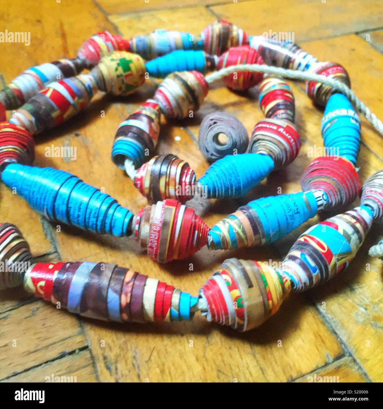 Handmade paper beads on the parquet floor Stock Photo - Alamy