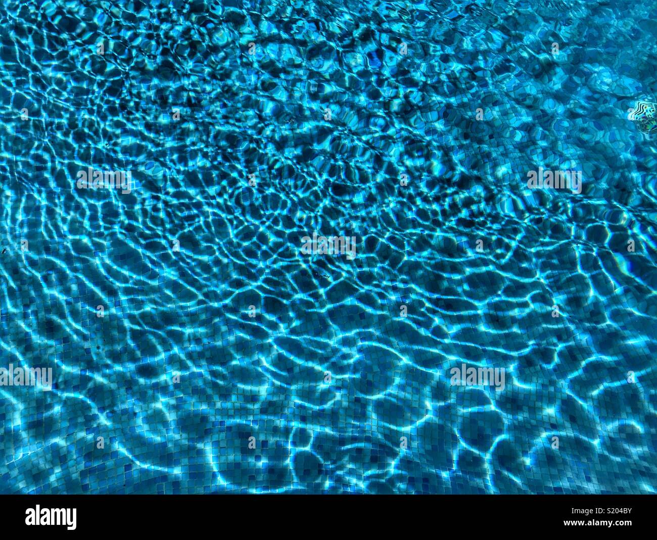 Sunlight on ripples in swimming pool water Stock Photo - Alamy