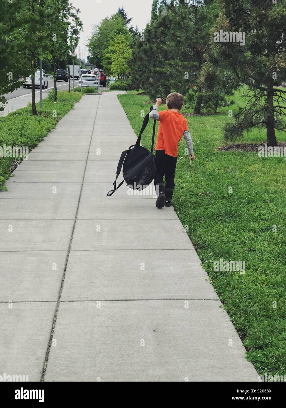Little boy carrying big backpack Stock Photo - Alamy