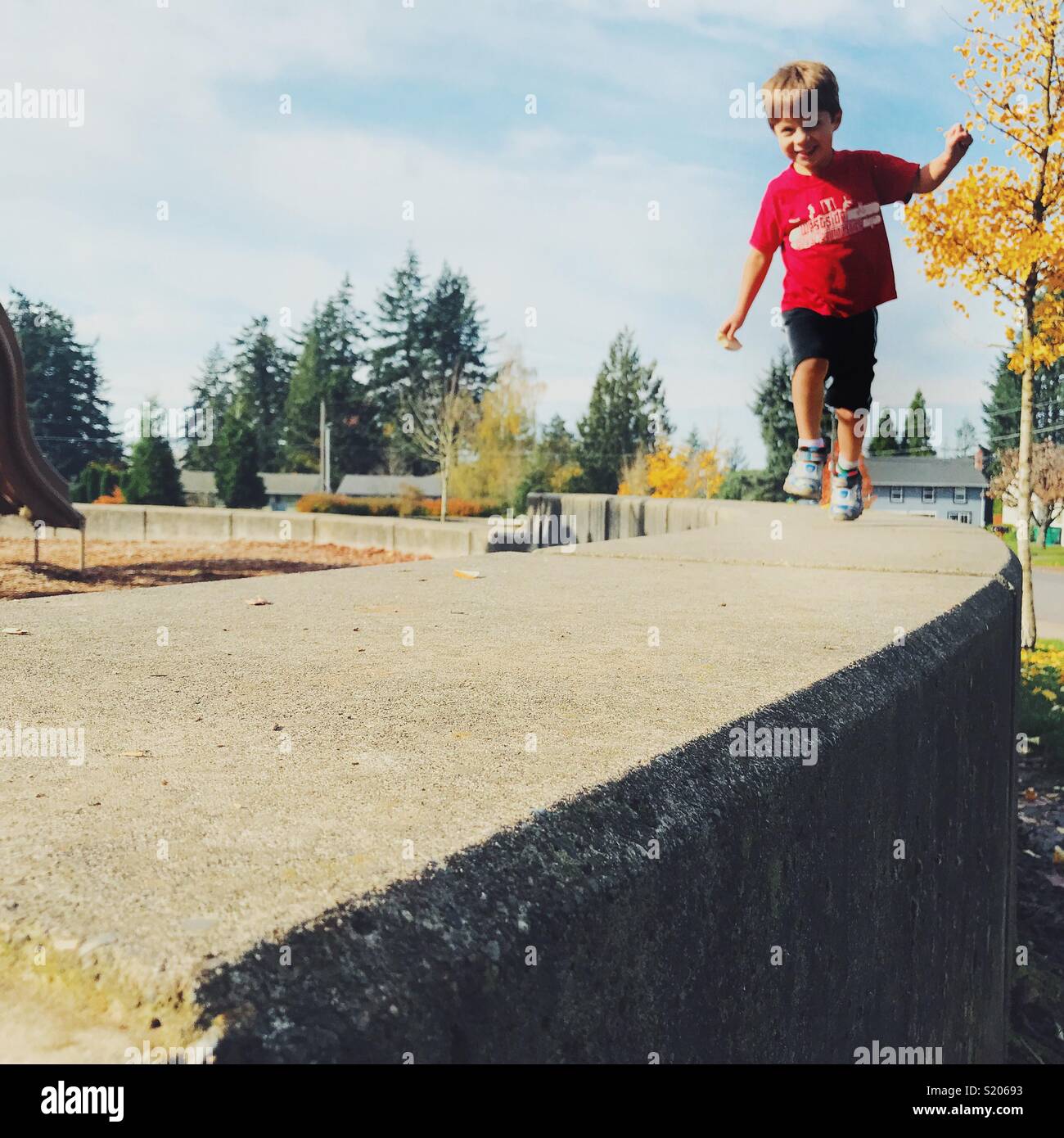 Happy boy running on ledge Stock Photo - Alamy