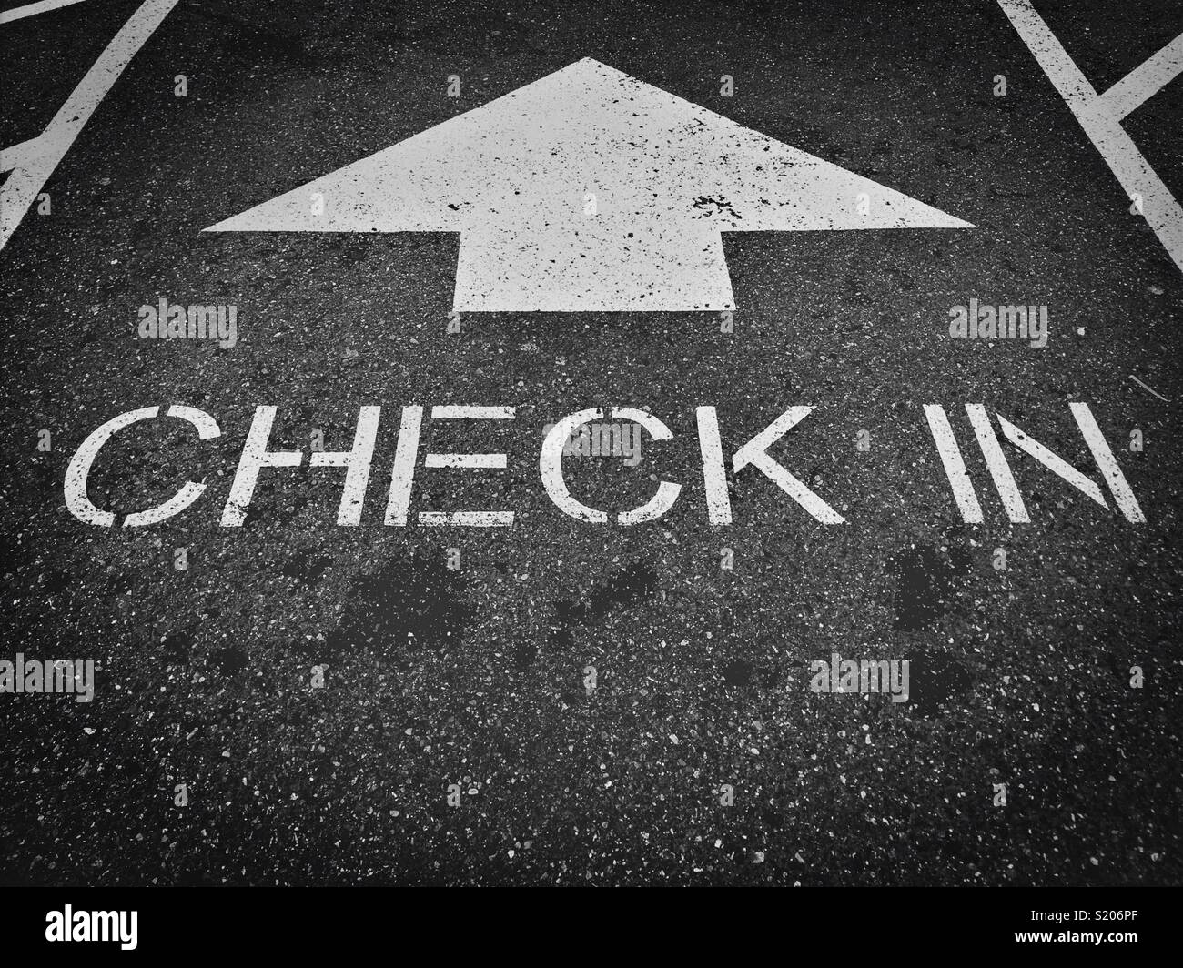 The word’s “ check in” painted on parking lot asphalt Stock Photo - Alamy