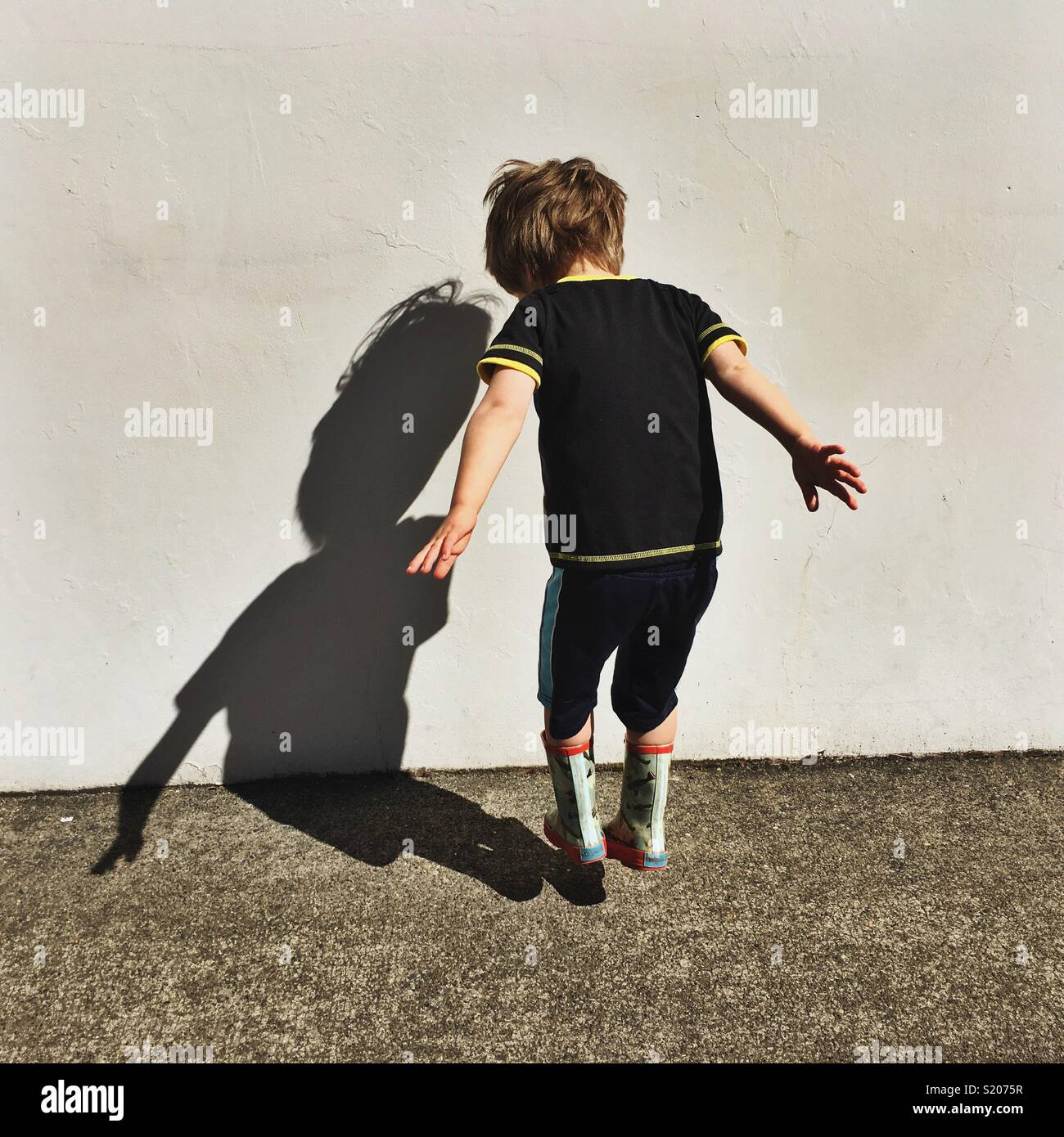 Boy jumping with shadow Stock Photo - Alamy
