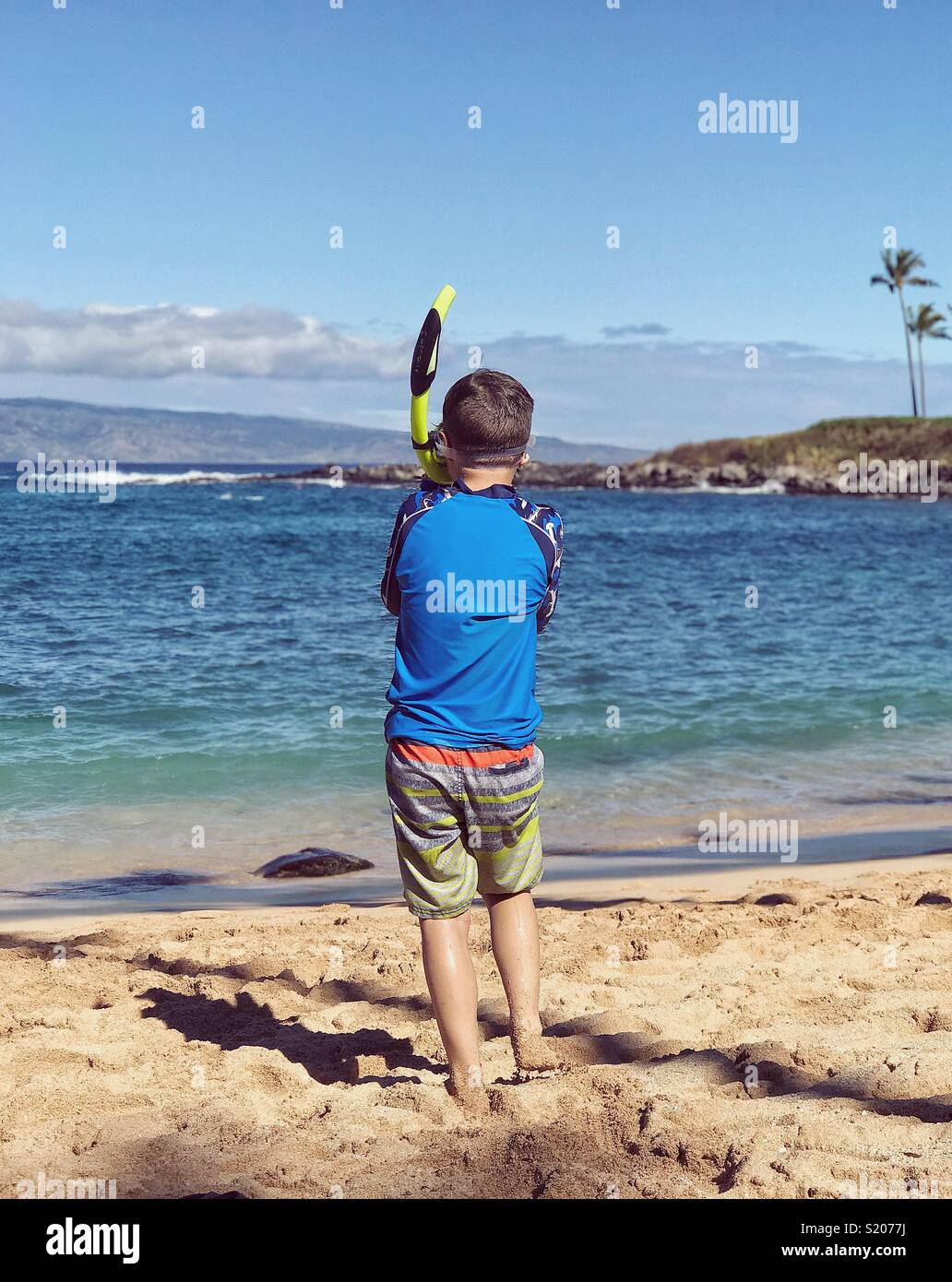 Boy looking out at ocean in Hawaii in snorkel Stock Photo - Alamy