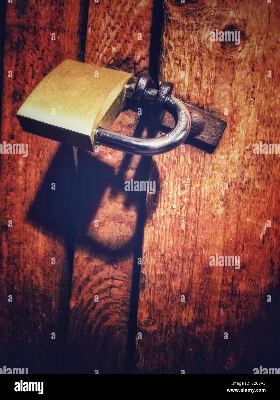 Closed padlock with shadow on a rough and weathered wooden door Stock ...
