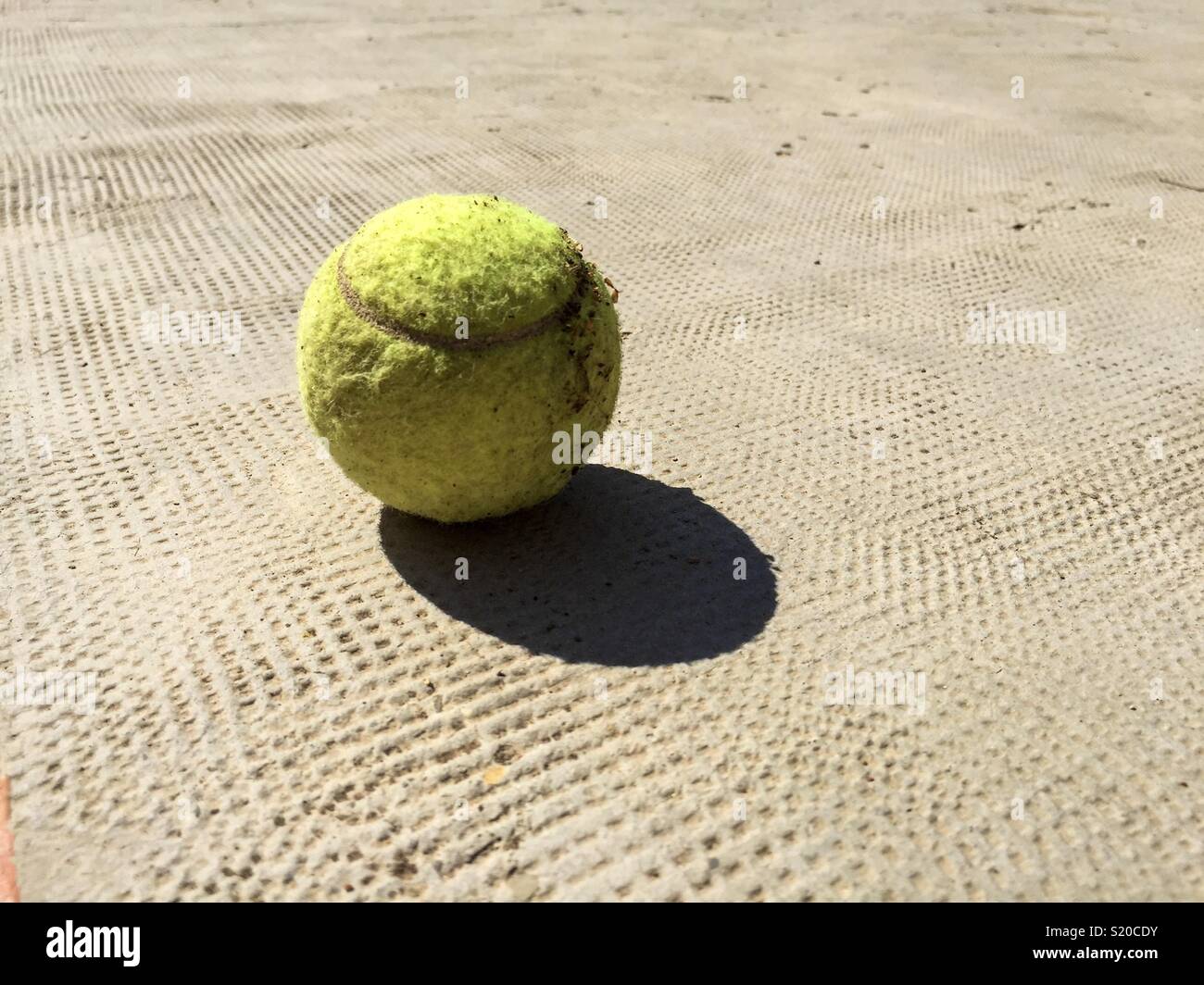 Tennis ball in the ground Stock Photo - Alamy