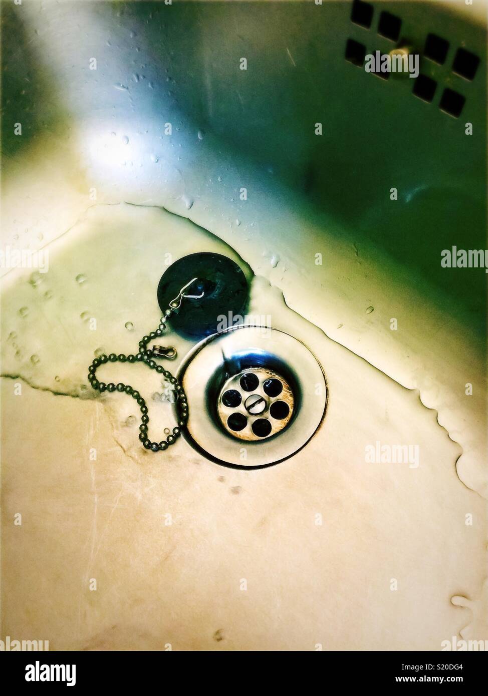Kitchen sink with water and a basin plug Stock Photo - Alamy