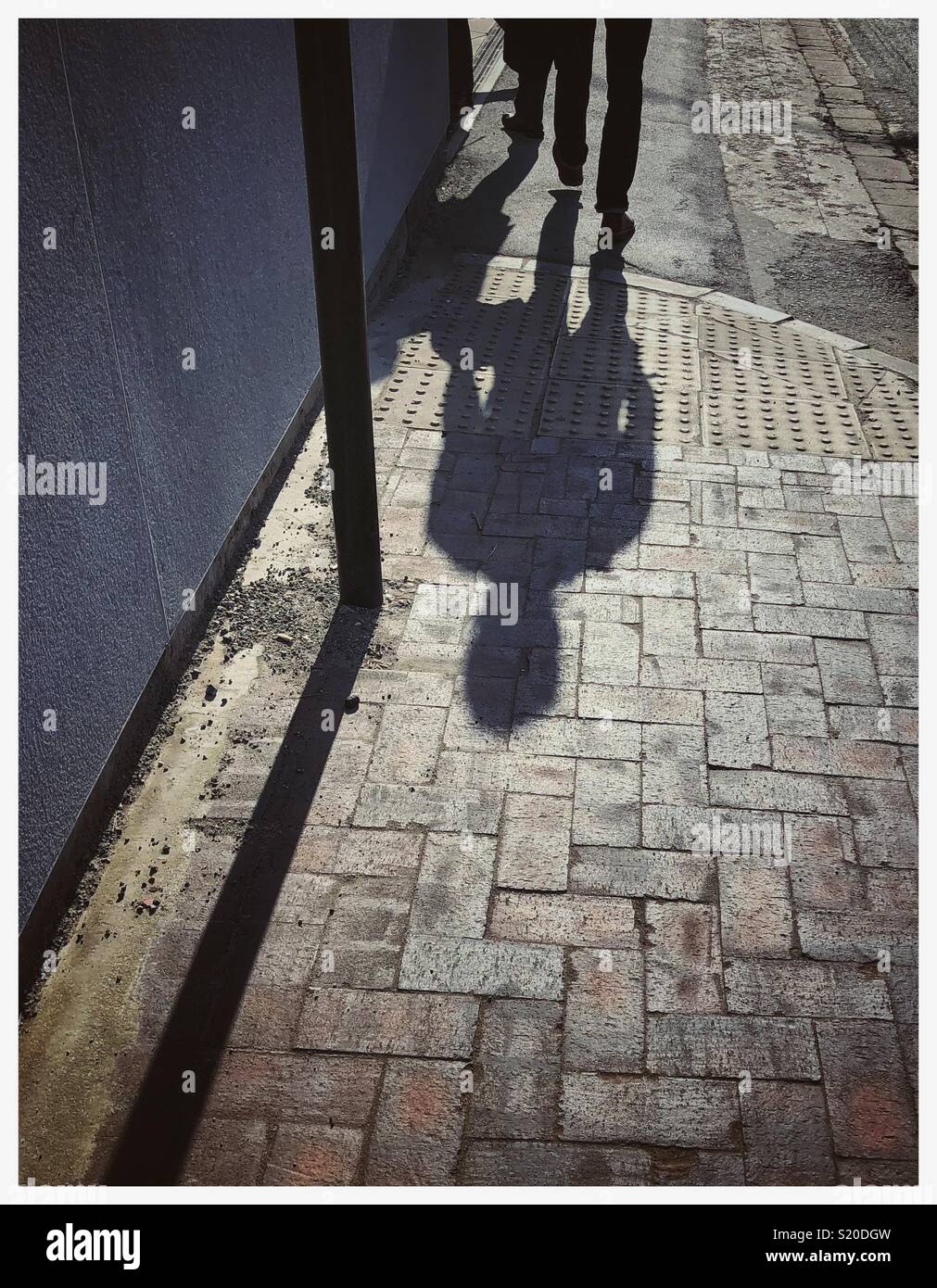 Shadow of person on a paved street Stock Photo - Alamy