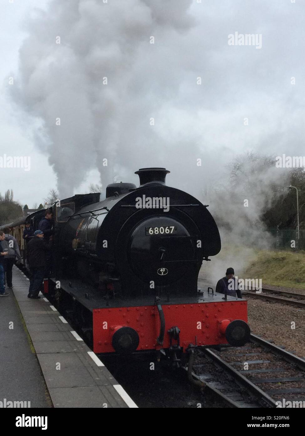 Tank engine arrives at platform in the rain Stock Photo - Alamy