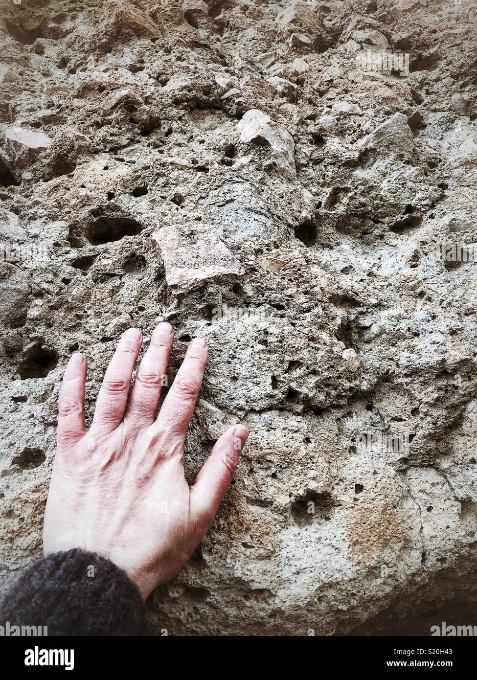 Touching an ancient rock Stock Photo - Alamy