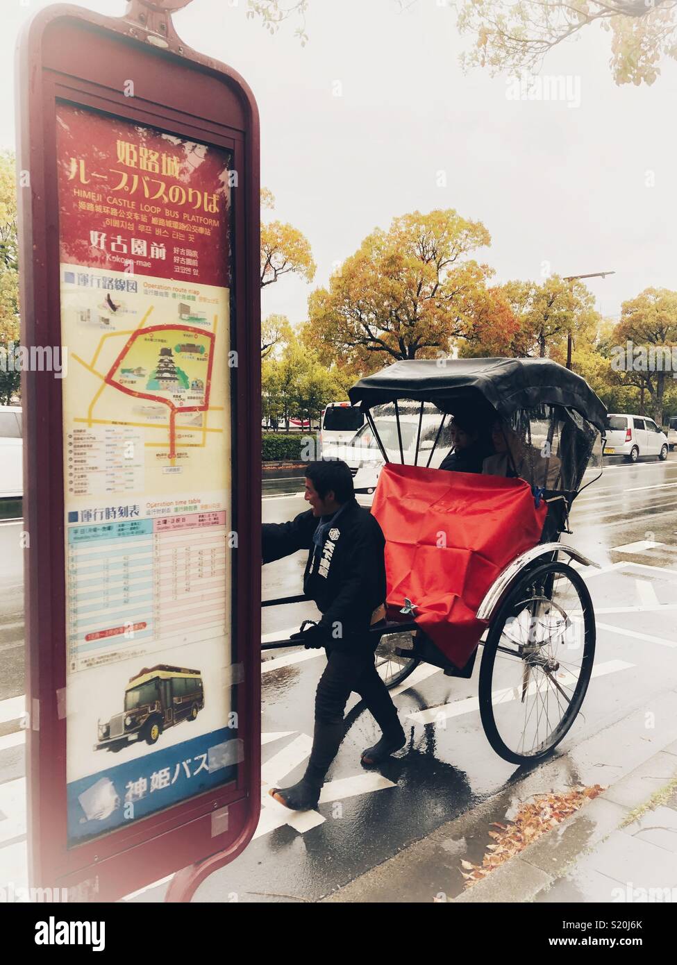 Tourists travel the streets of Himeji, Japan in a man-drawn carriage ...