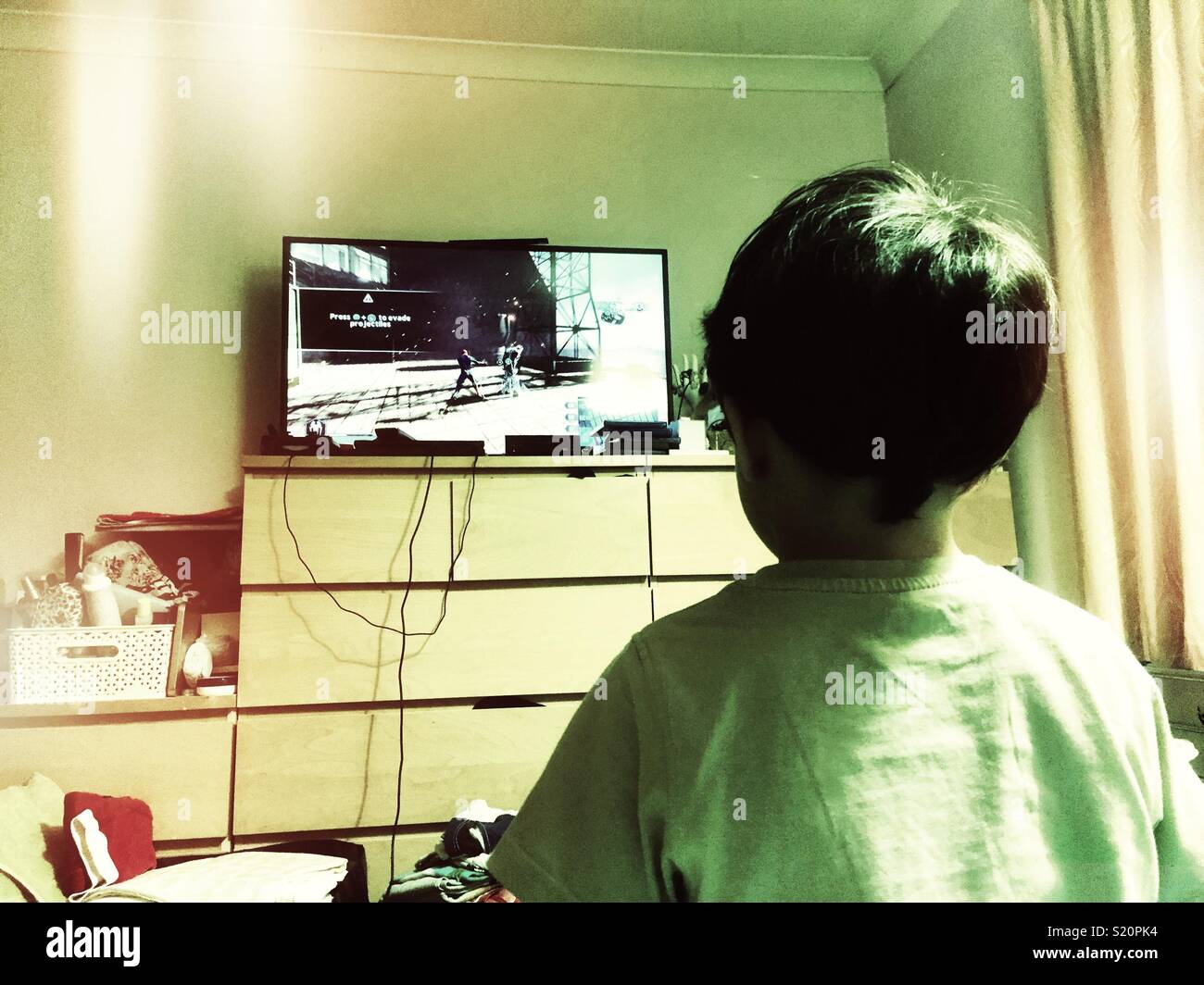 A young boy seen from behind playing video games Stock Photo - Alamy