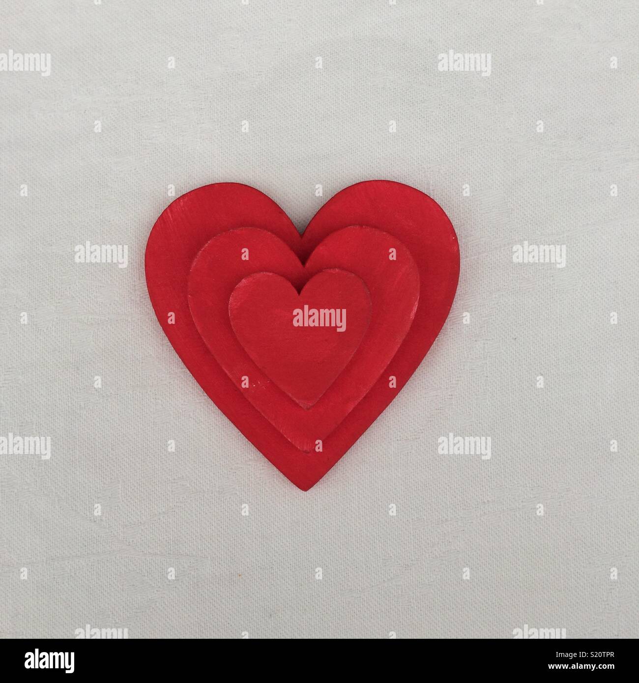 Three concentric wooden hearts on plain background Stock Photo - Alamy