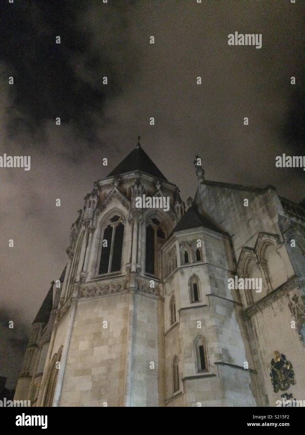 The Royal Court of Justice at night with the moody sky emphasising the ...