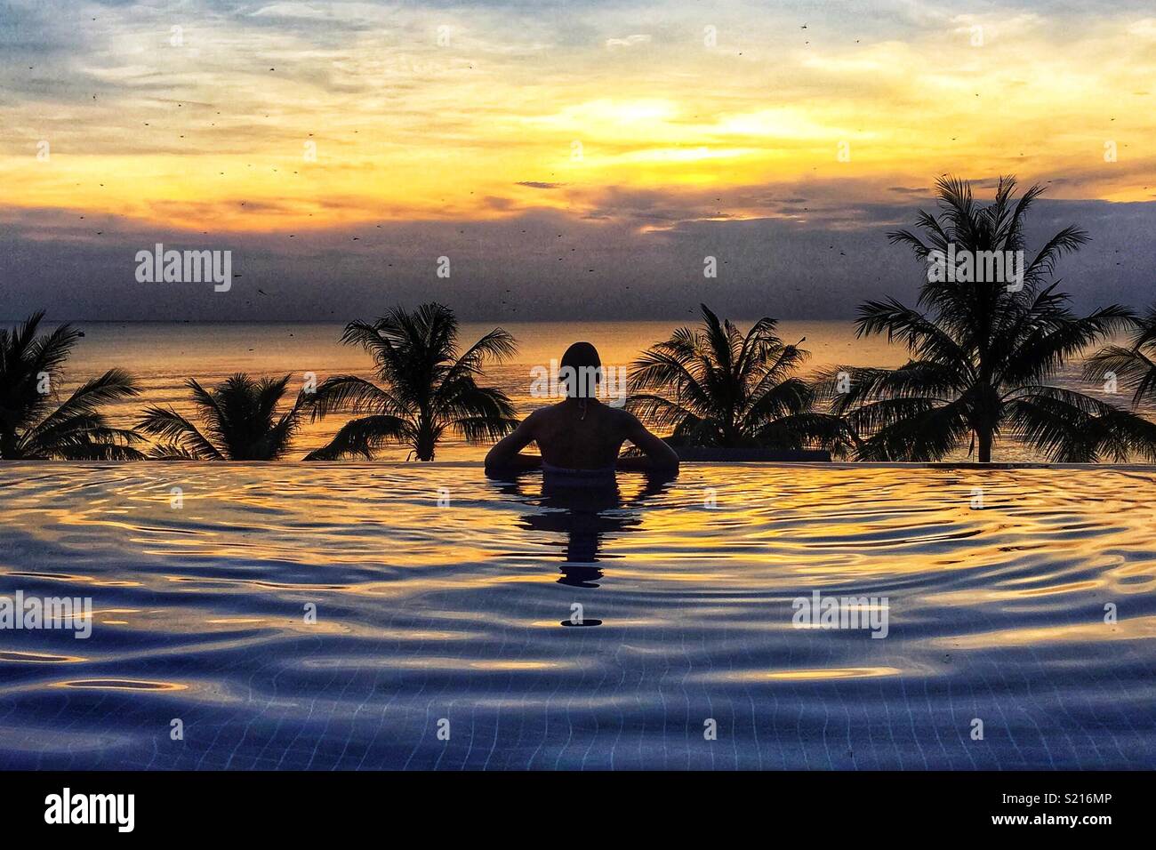 Infinity pool in the sunset Stock Photo - Alamy