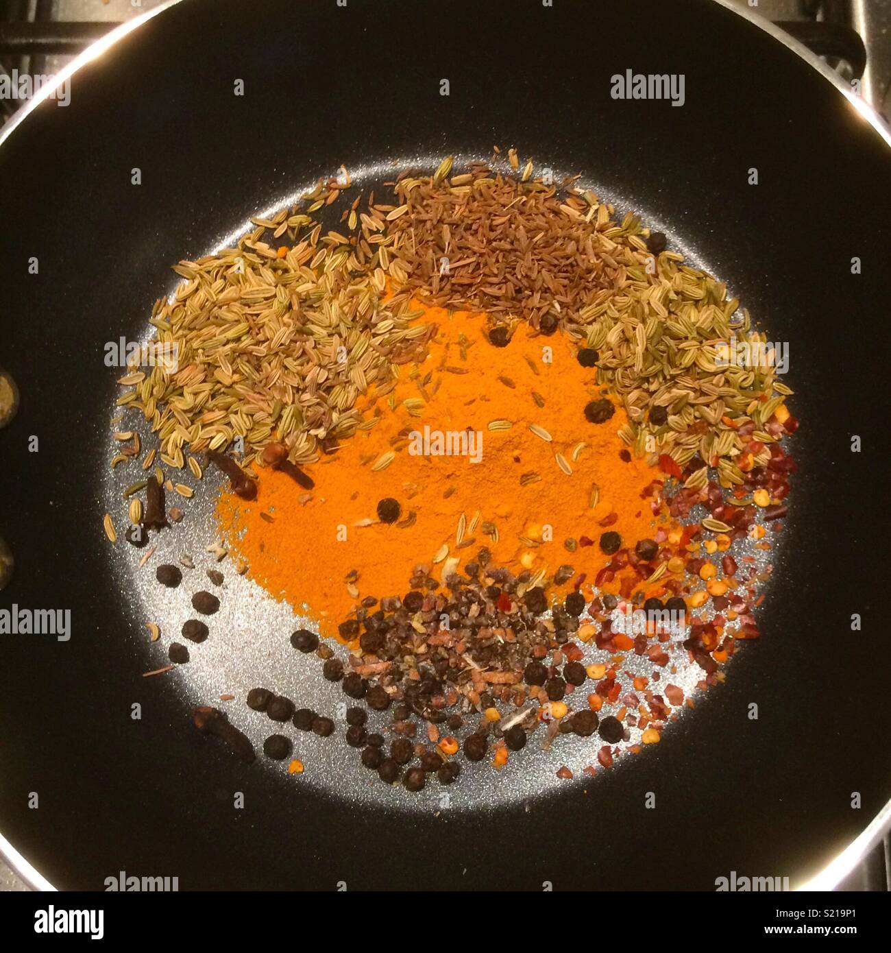 Spices in a pan for curry paste Stock Photo - Alamy