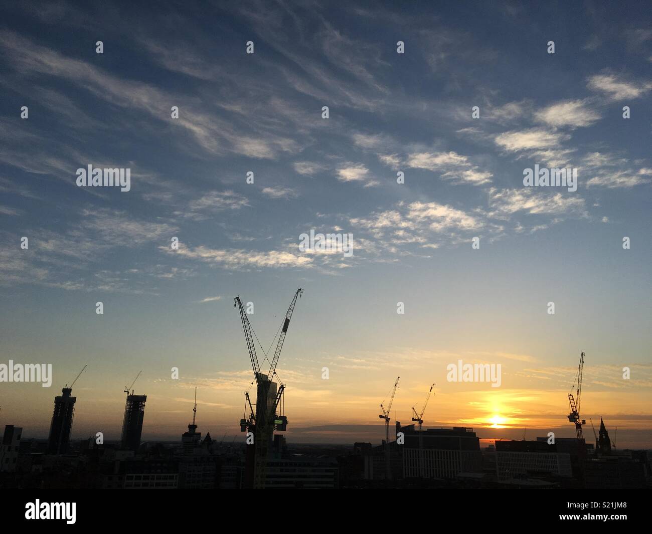Cranes over Manchester skyline at sunset. Manchester, England. UK Stock ...