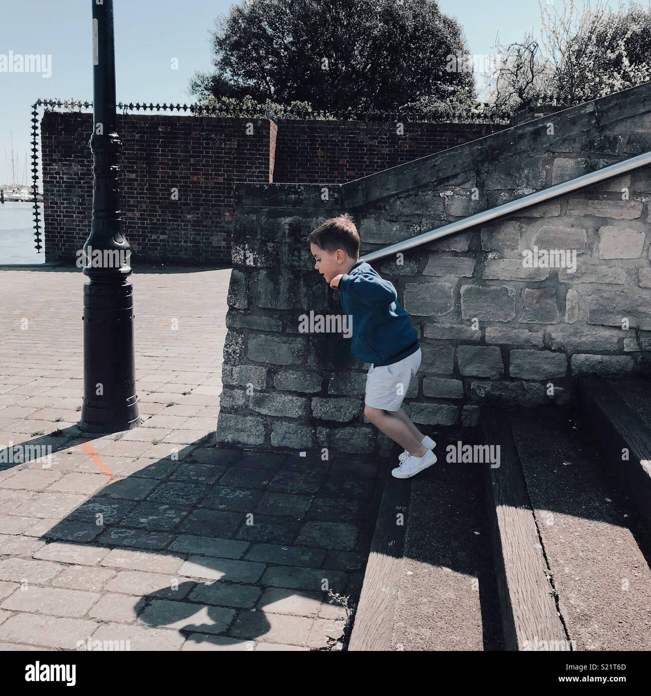 Photo of a little boy jumping down some steps outside Stock Photo - Alamy