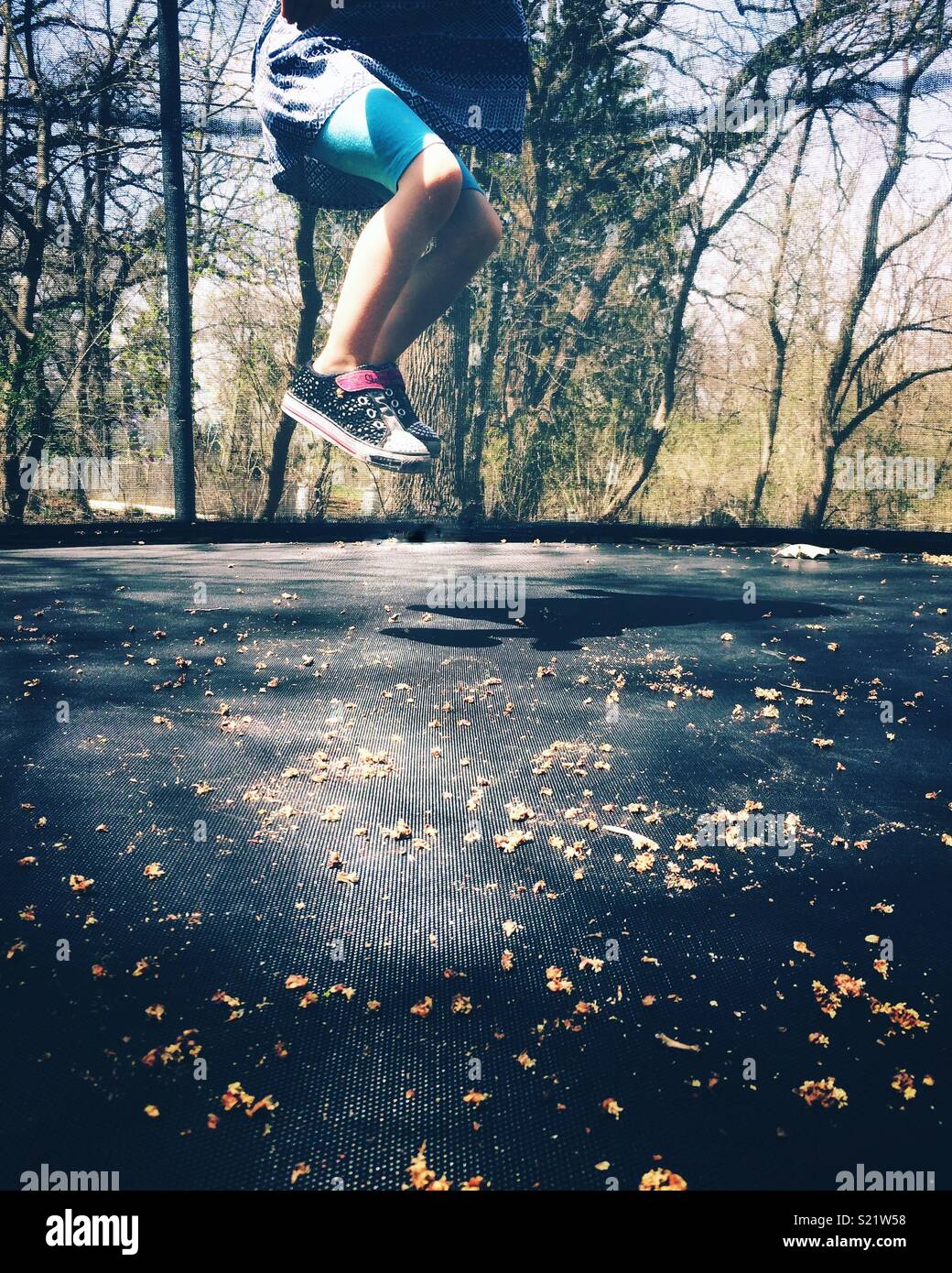 Girl jumping bouncing on a trampoline Stock Photo - Alamy