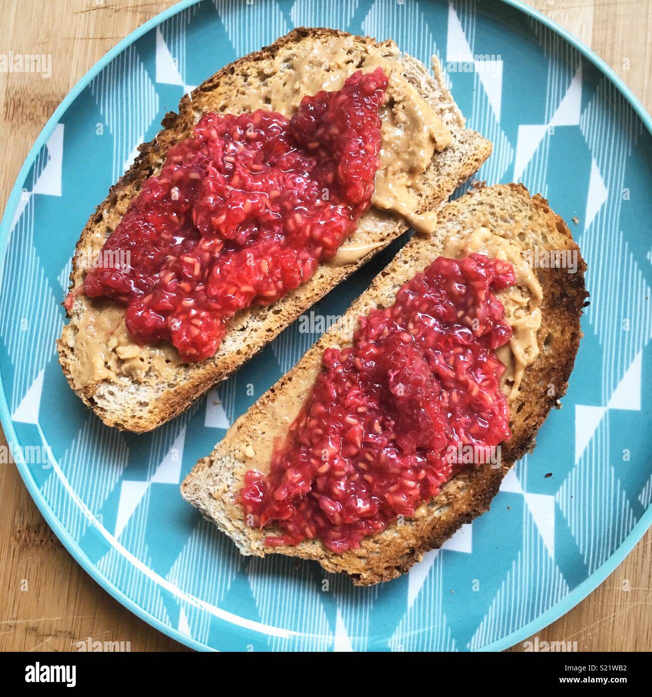 Crushed raspberries on sourdough toast with peanut butter on a ...