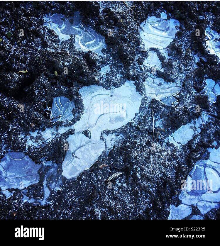 Iced puddles up a country lane greater manchester Stock Photo - Alamy