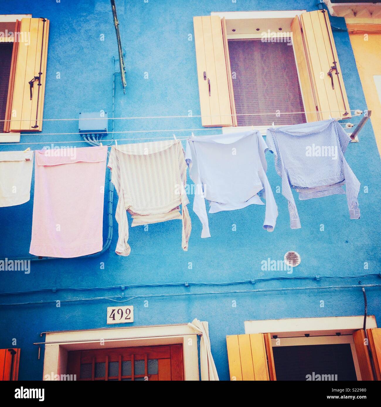 Clothes drying against blue building in Venice Stock Photo - Alamy