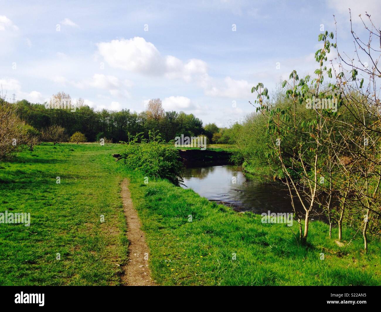 Views in Reddish Vale Country Park, showing the river and blue sky ...
