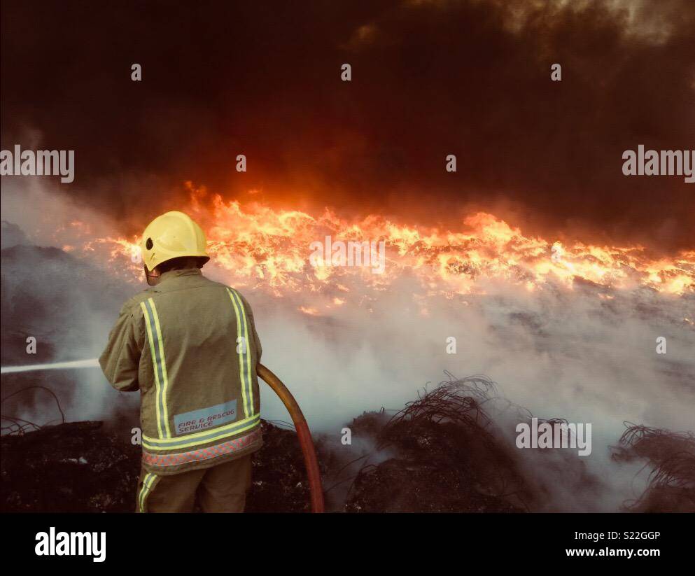 A firefighter dealing with an intense fire Stock Photo - Alamy