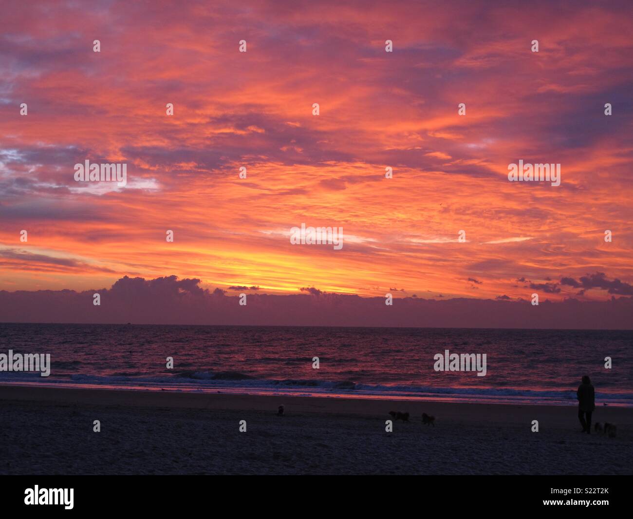 Moody, red, winter sunrise on beach Stock Photo - Alamy