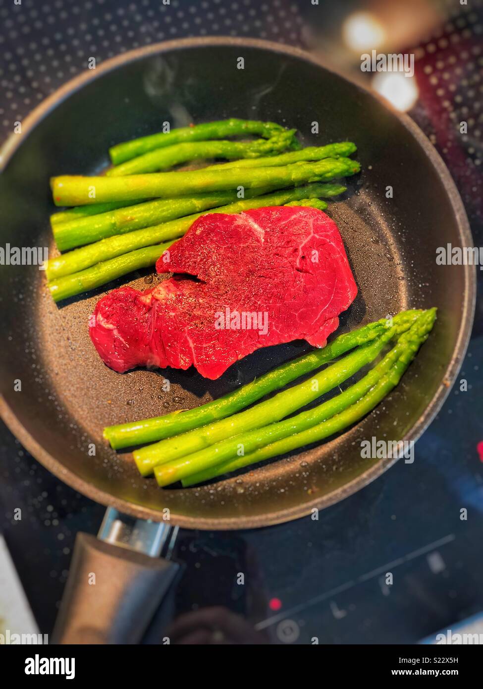 Steak and asparagus cooking Stock Photo - Alamy