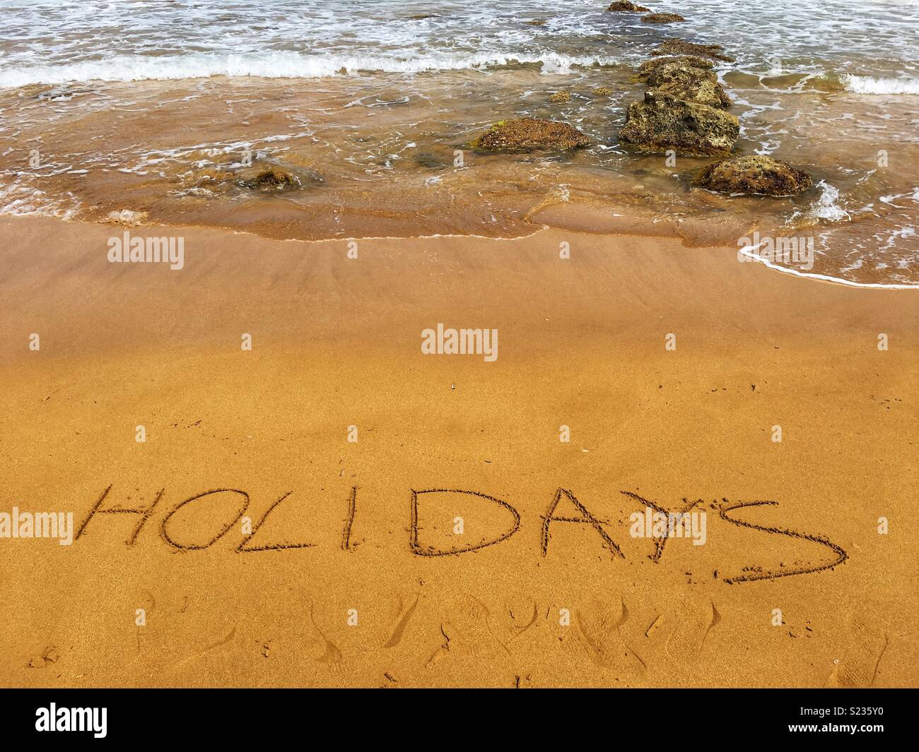 Holidays text on beach Stock Photo - Alamy
