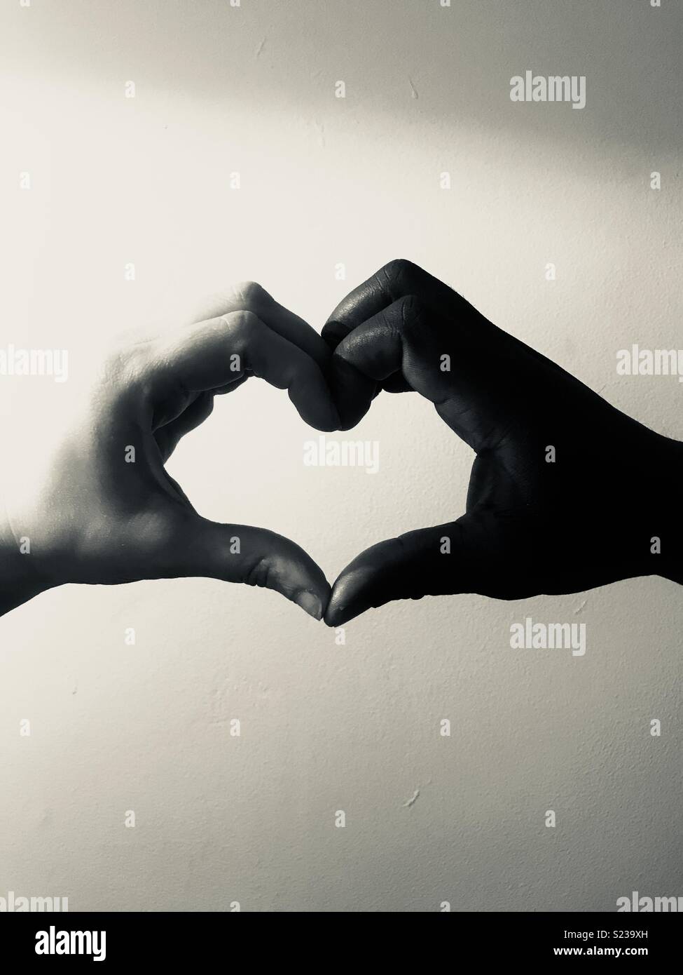Biracial couple hands forming a heart Stock Photo - Alamy
