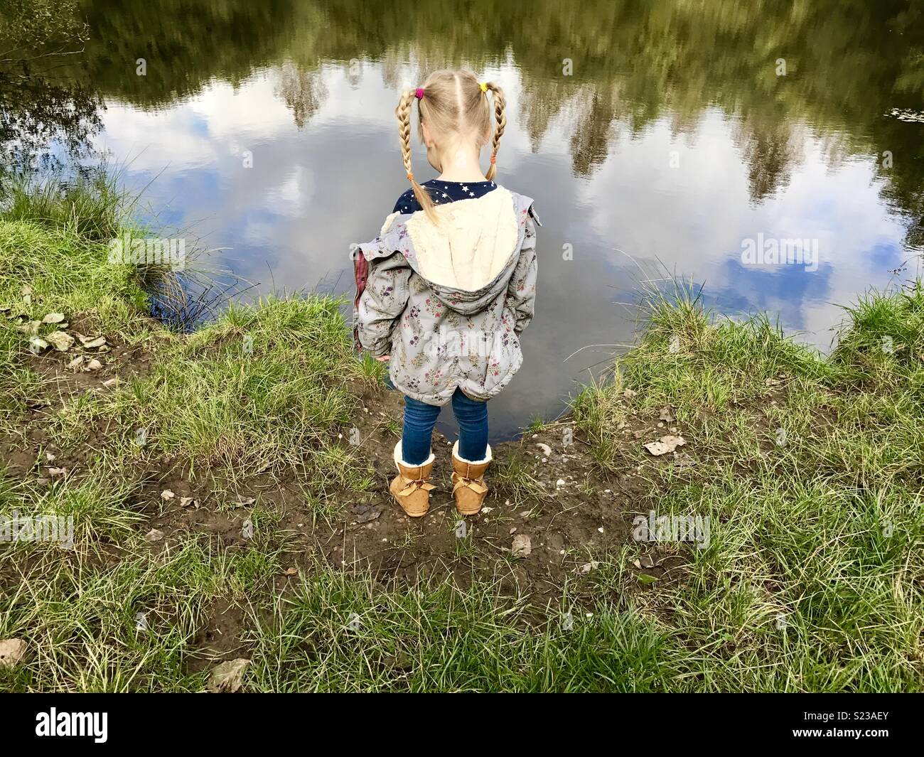 Little girl stares into pond Stock Photo - Alamy