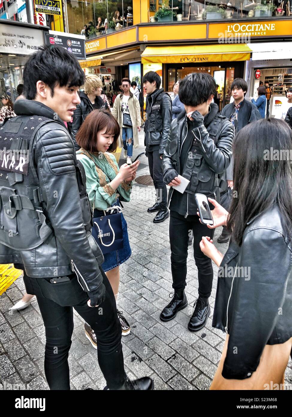 Young Japanese talking on a street corner in Tokyo Stock Photo - Alamy