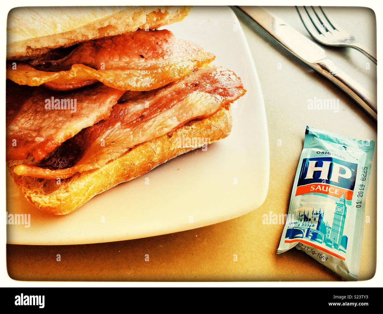 HP sauce sachet and bacon roll Stock Photo - Alamy