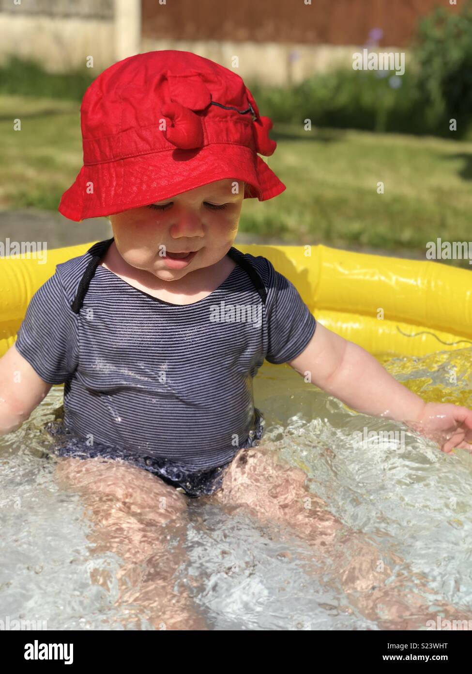 Baby enjoying a splash in the pool Stock Photo - Alamy