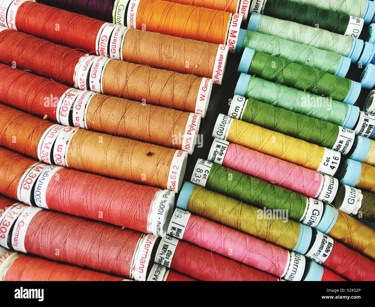 Roles of coloured sewing threads on display Stock Photo - Alamy