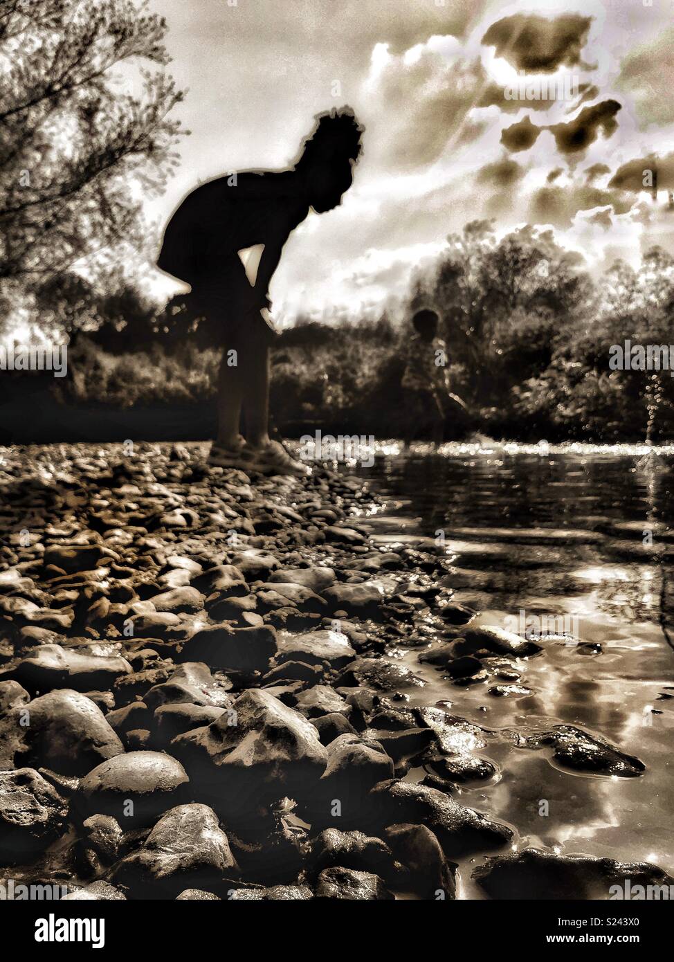 Children playing on a river bank Stock Photo - Alamy