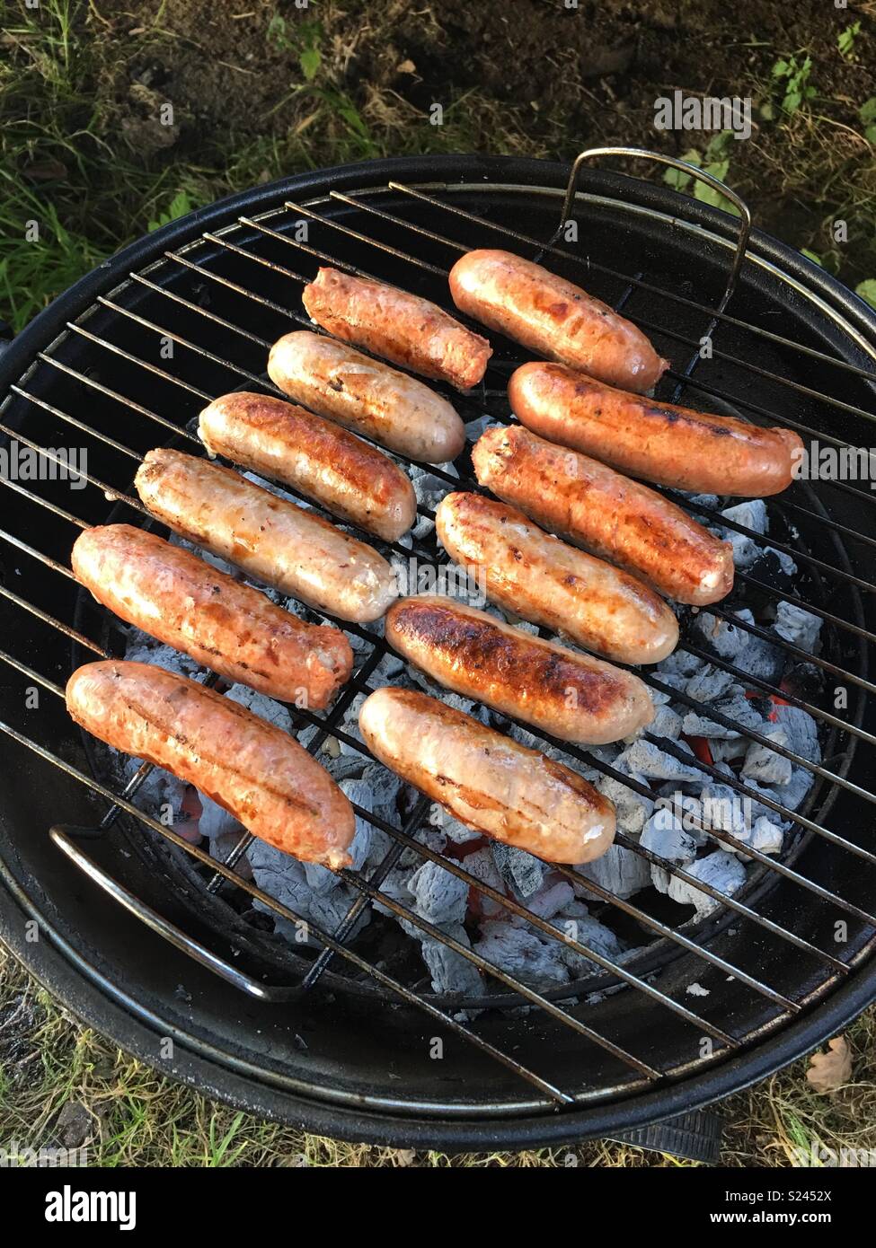 Sausages cooking on a barbecue Stock Photo - Alamy