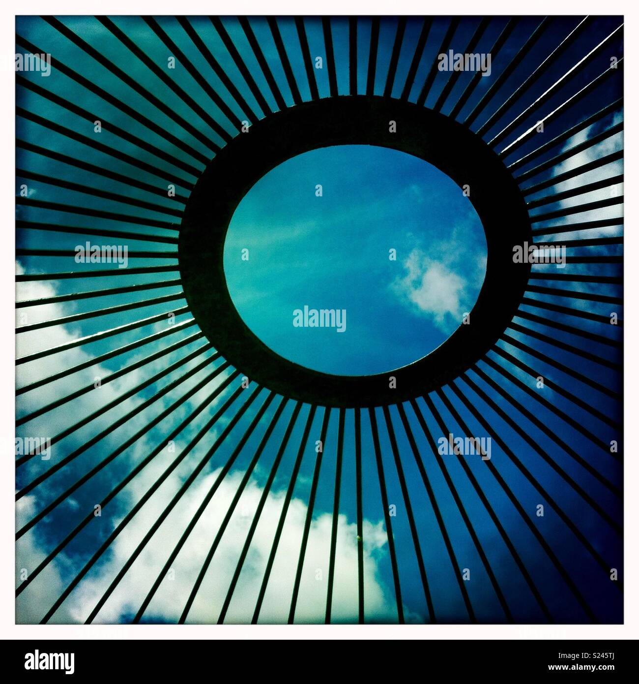 Sky with clouds showing through a round opening with spokes Stock Photo ...